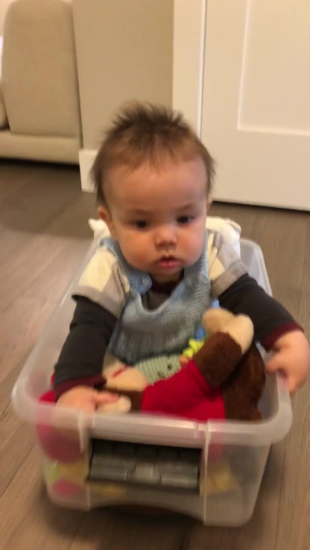 Baby Rides on Robotic Vacuum Sitting in a Plastic Container - Poke My Heart